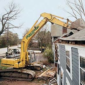 Construction equipment demolishing a house.